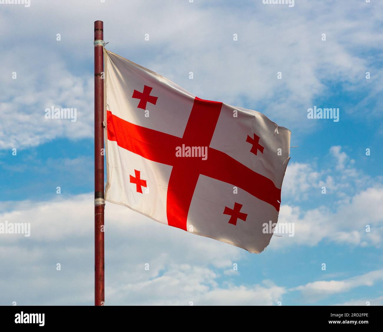 Flag of Georgia waving on cloudy sky Stock Photo - Alamy