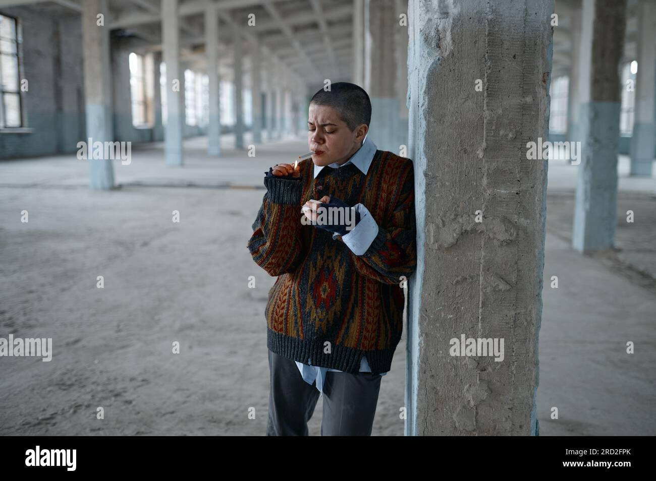 Homeless punk woman barely standing on her feet leaned on column Stock ...