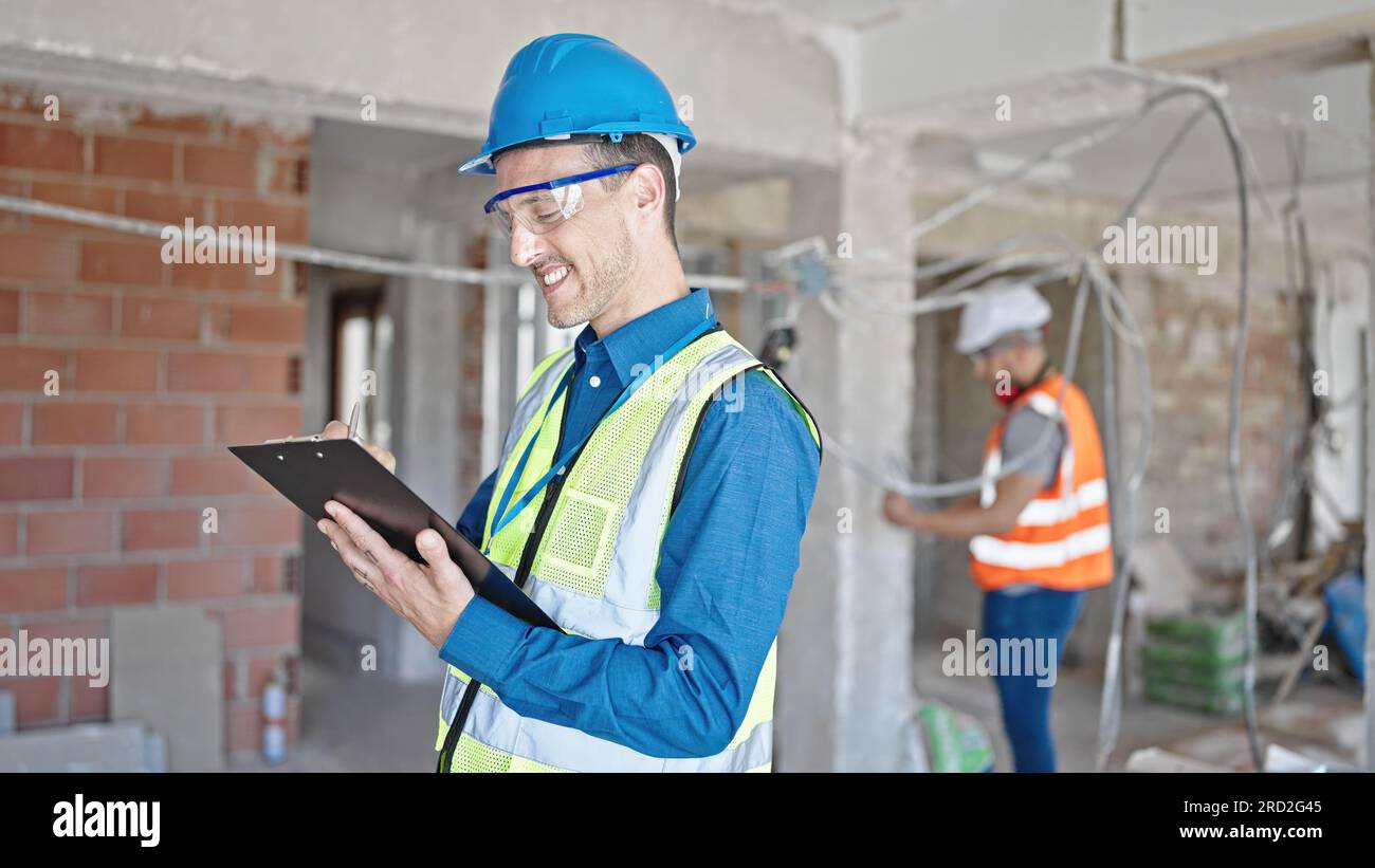 Two men builders writing document working at construction site Stock ...