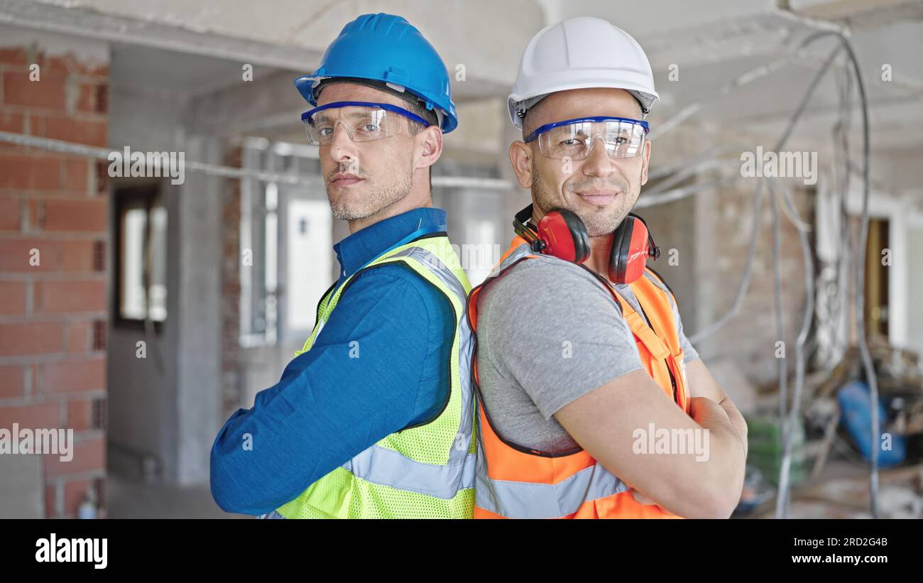 Two men builders smiling confident standing with arms crossed gesture ...
