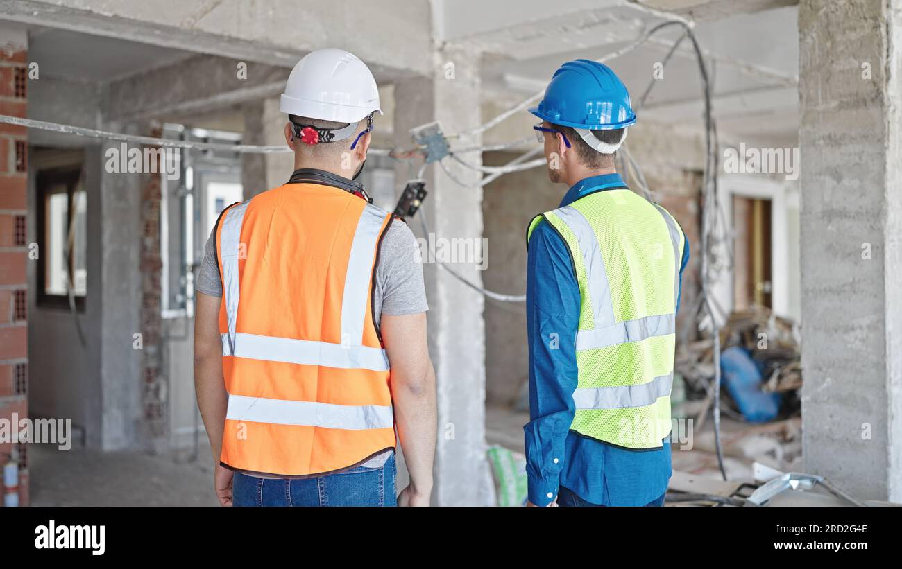 Two men builders standing together backwards at construction site Stock ...