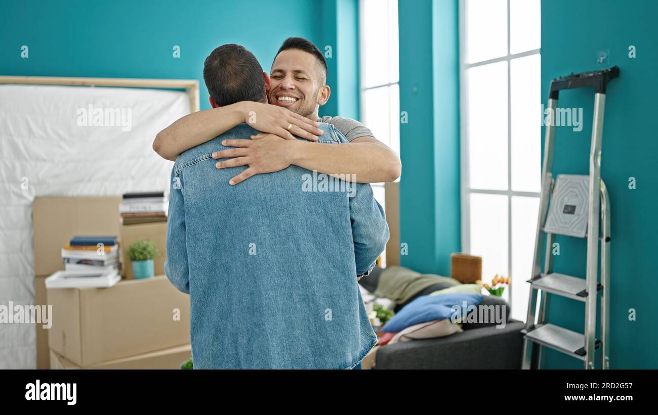 Two men smiling confident hugging each other at new home Stock Photo ...