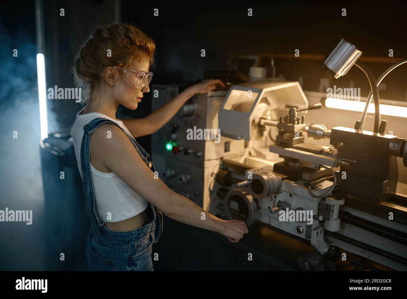 Young blond woman mechanical engineer working on lathe machine Stock ...