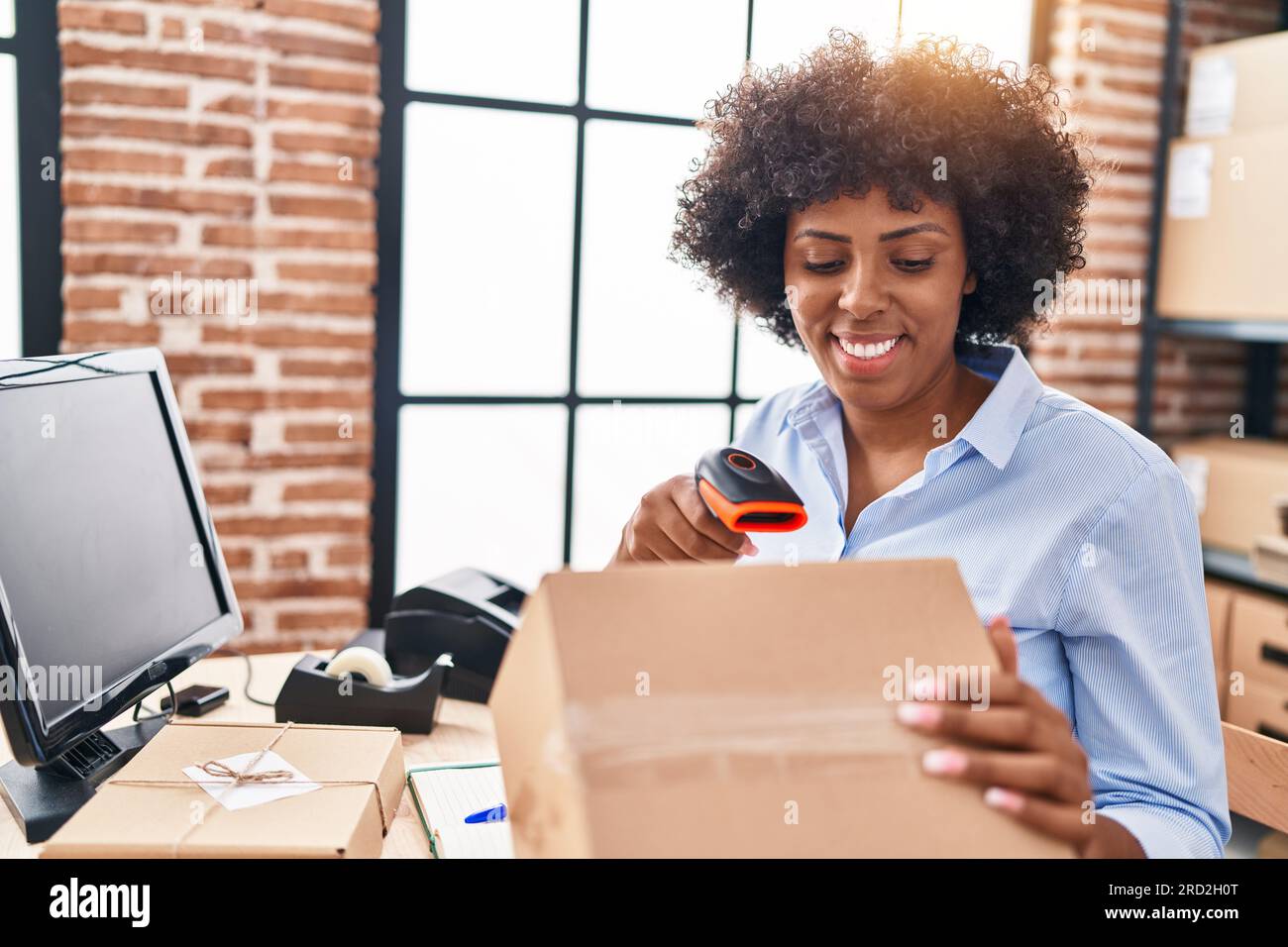 African american woman ecommerce business worker scanning package at ...