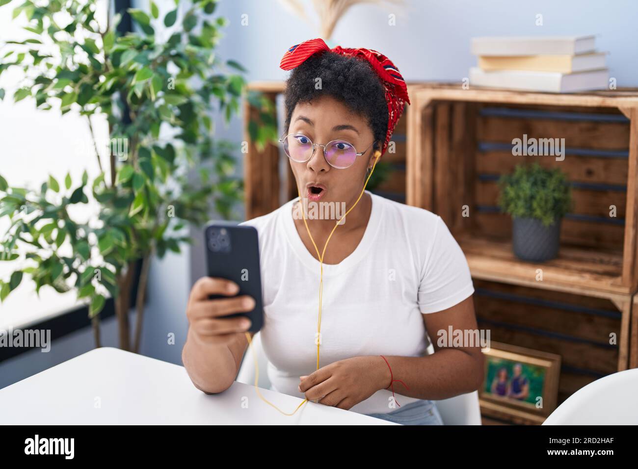 Young african american woman doing video call with smartphone scared ...