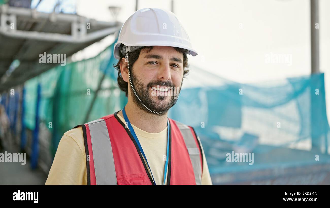 Young hispanic man builder smiling confident standing at street Stock ...