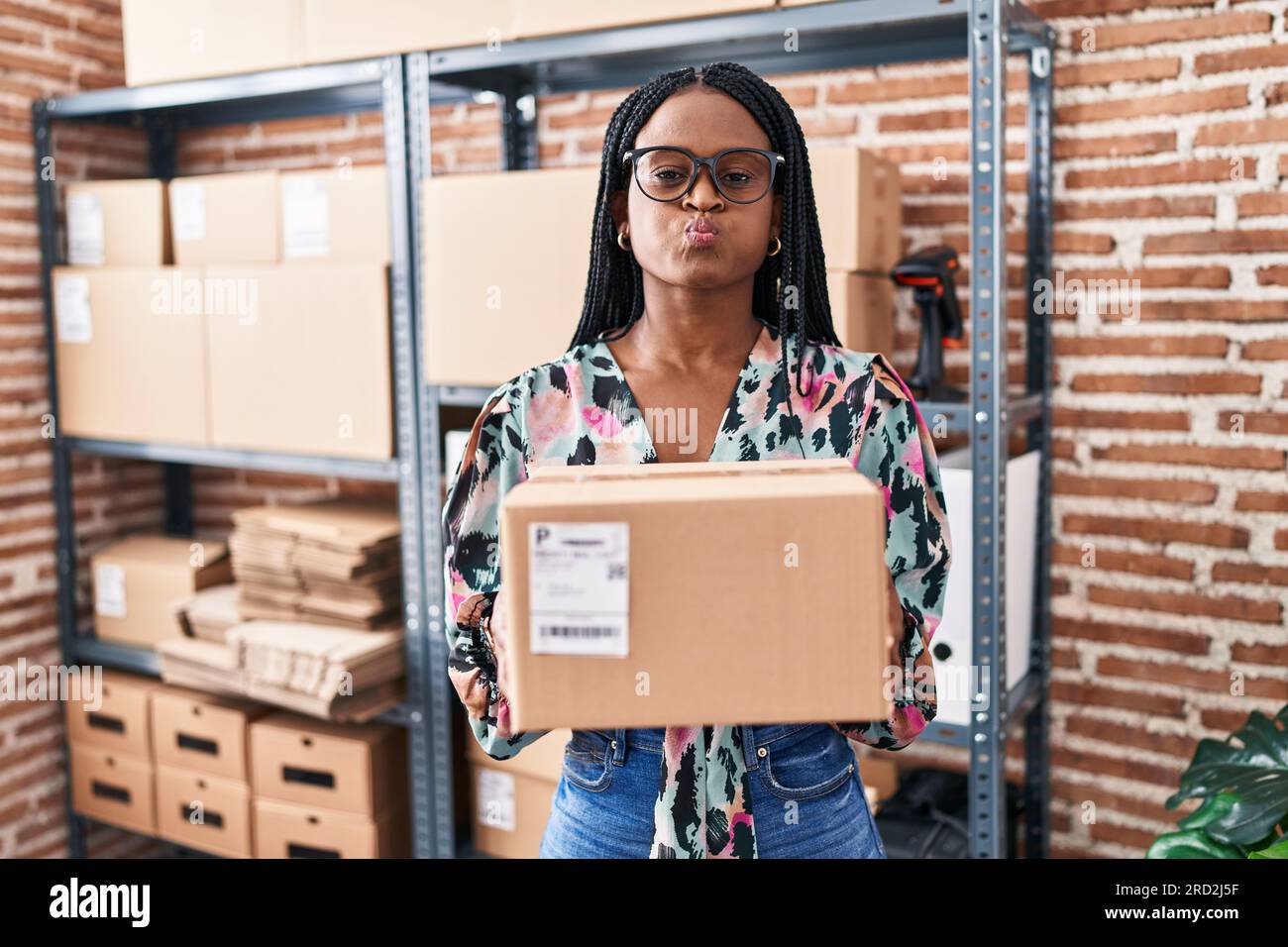 African woman with braids working at small business ecommerce holding ...