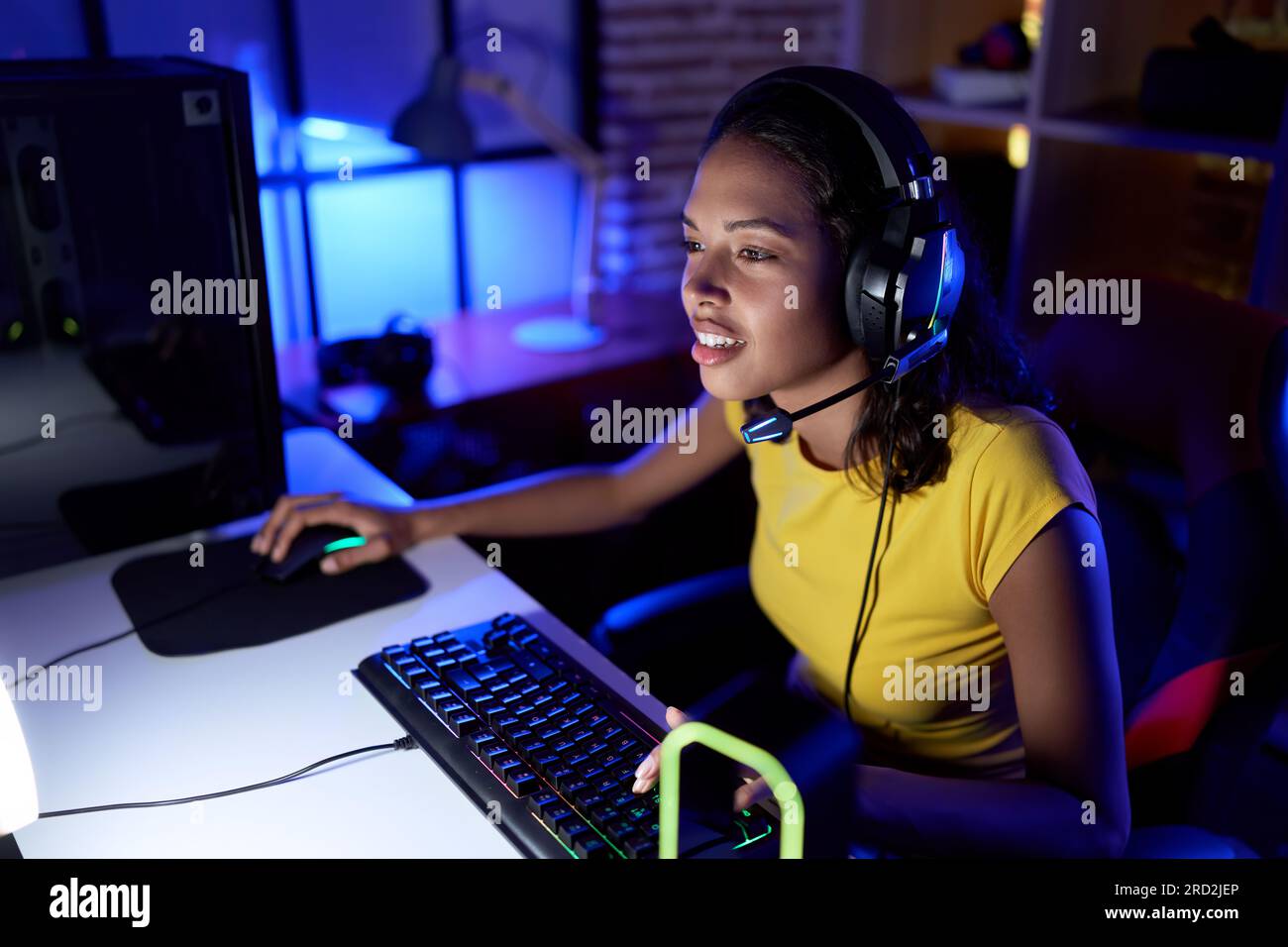 Young african american woman streamer playing video game using computer ...