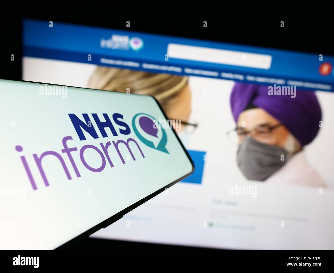 Smartphone with logo of Scottish health information service NHS inform on screen in front of ...