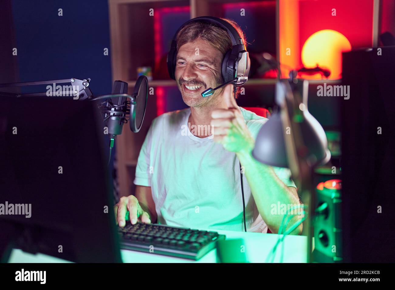 Caucasian man with mustache playing video games smiling happy and ...