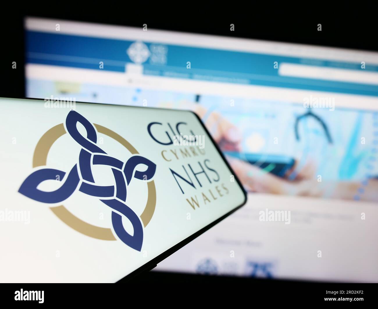 Mobile phone with logo of British healthcare system NHS Wales on screen ...