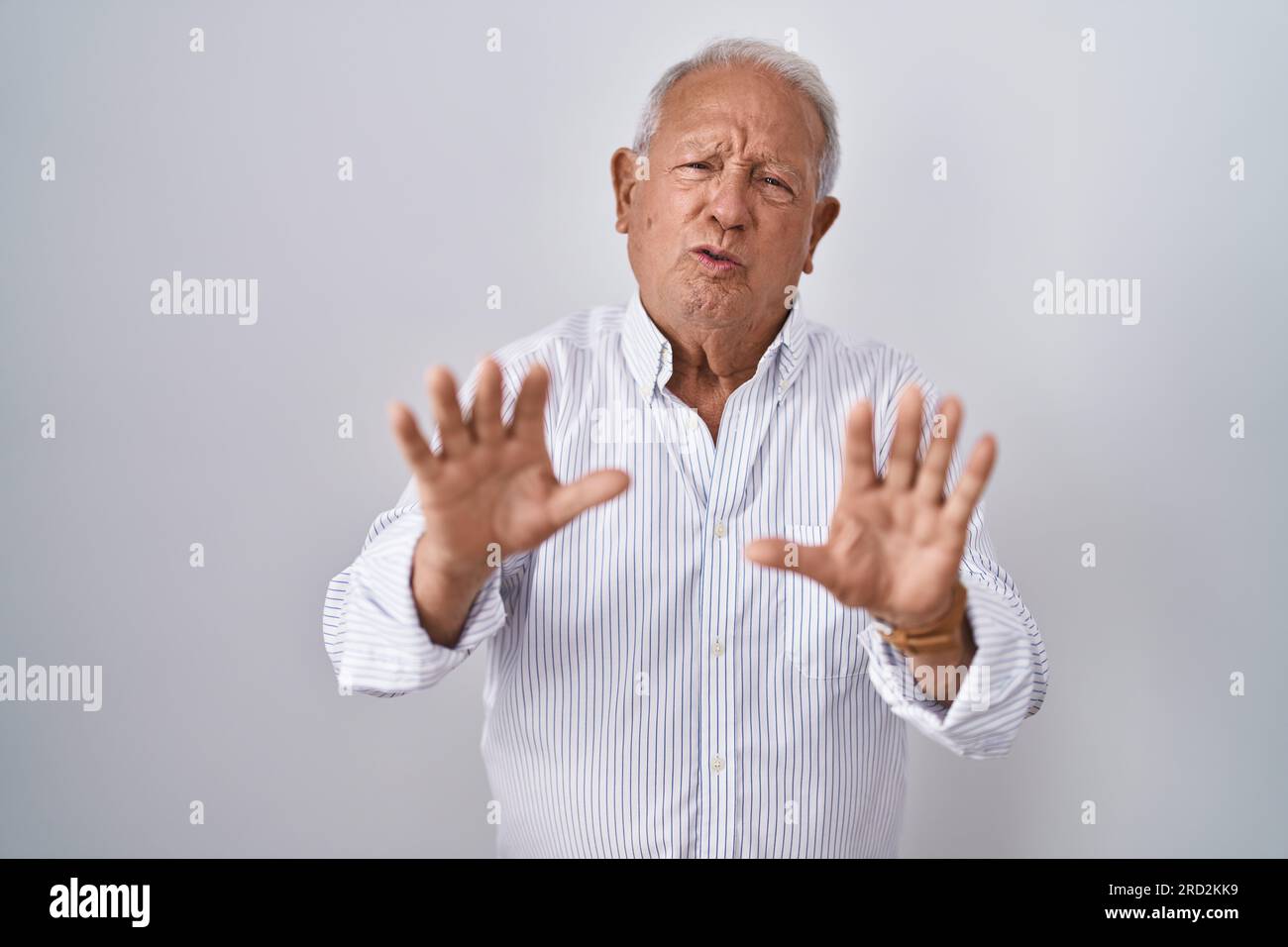 Senior man with grey hair standing over isolated background moving away ...