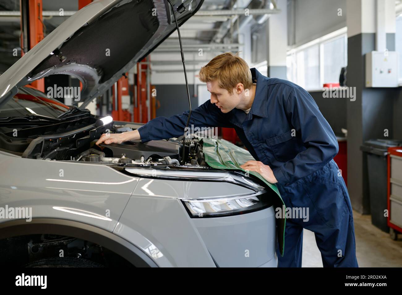 Automobile technician making manual diagnostics checkup of engine for ...