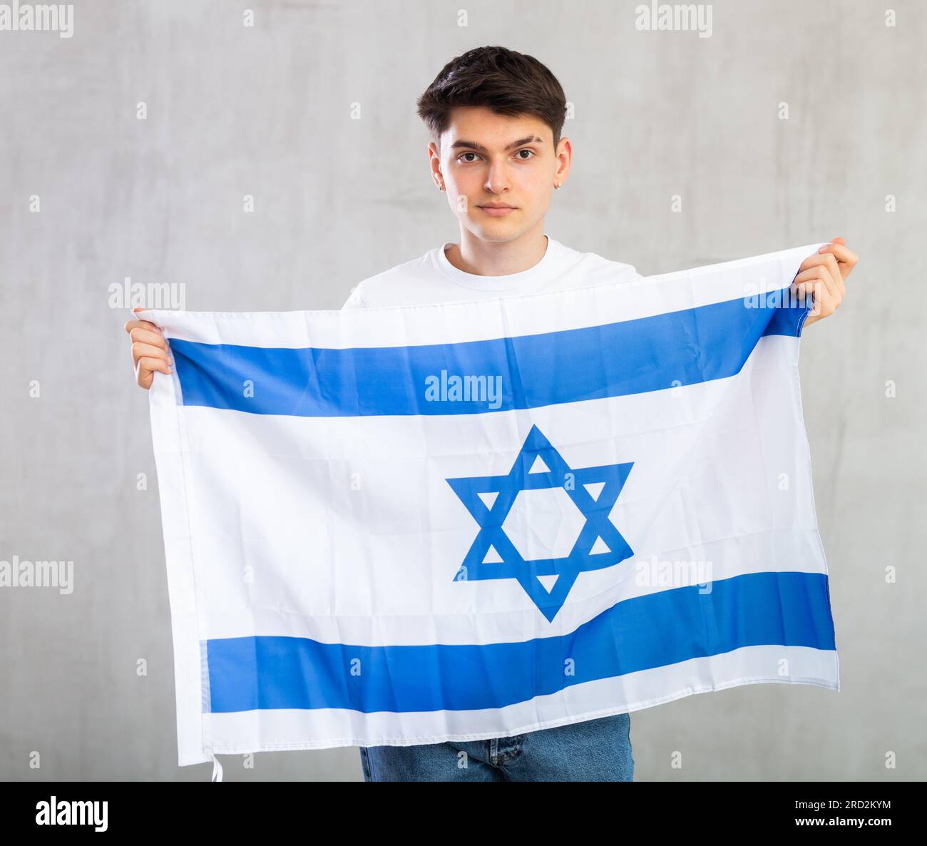Guy holding the Israel flag in her hands Stock Photo - Alamy