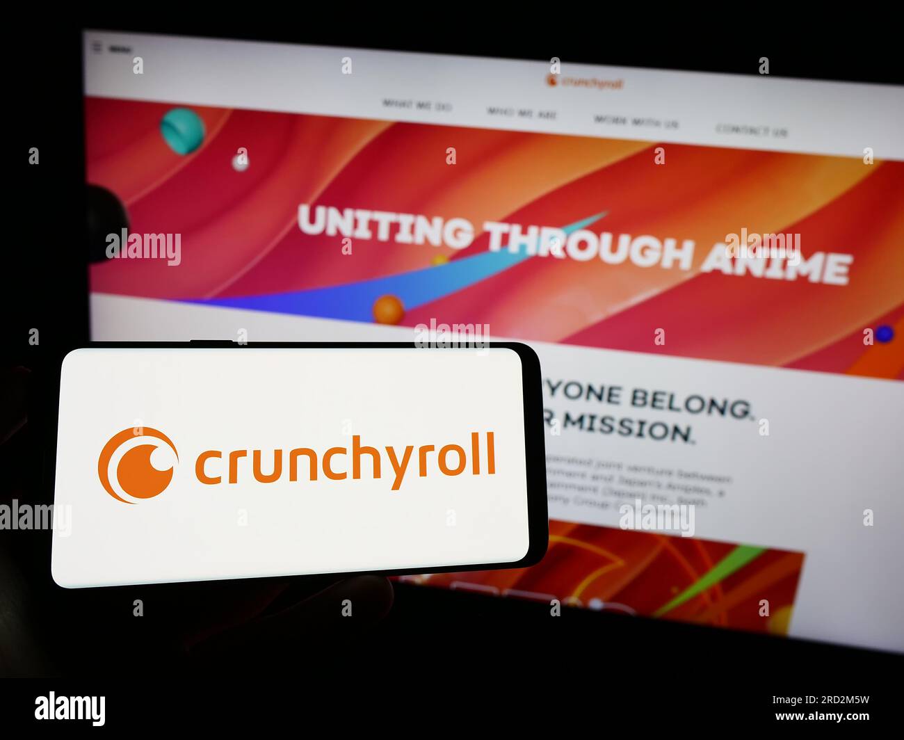 Person holding mobile phone with logo of American entertainment company ...