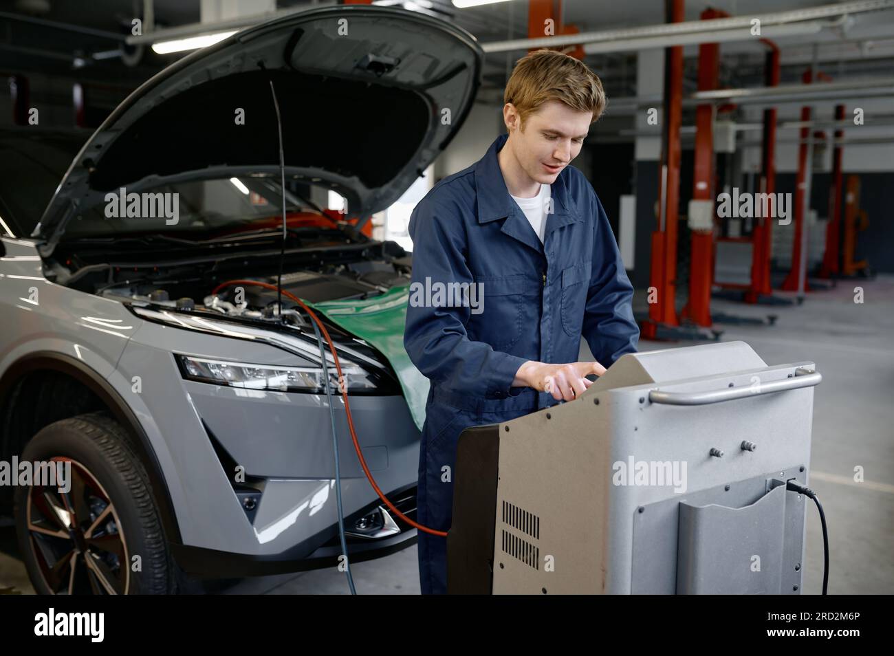 Repairman at car garage doing air conditioner or climate control ...