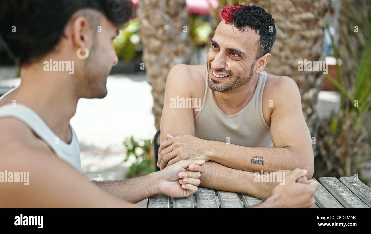 Two men couple sitting on table speaking at coffee shop terrace Stock ...