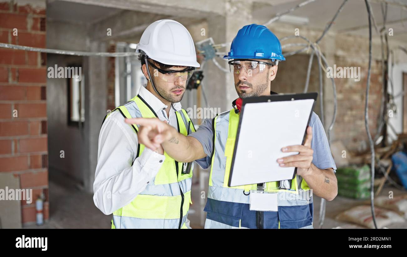Two men builders reading document at construction site Stock Photo - Alamy