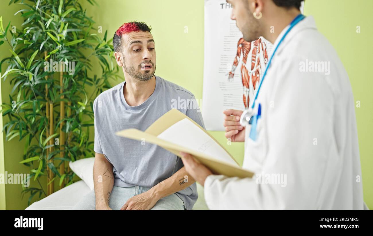 Two men doctor and patient having medical consultation speaking at ...