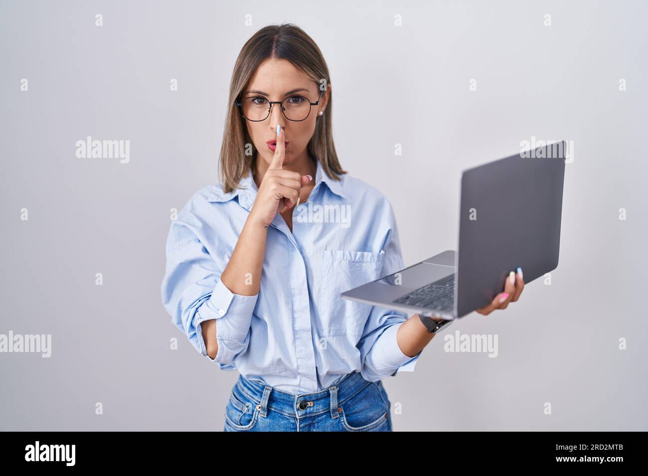 Young woman working using computer laptop asking to be quiet with ...