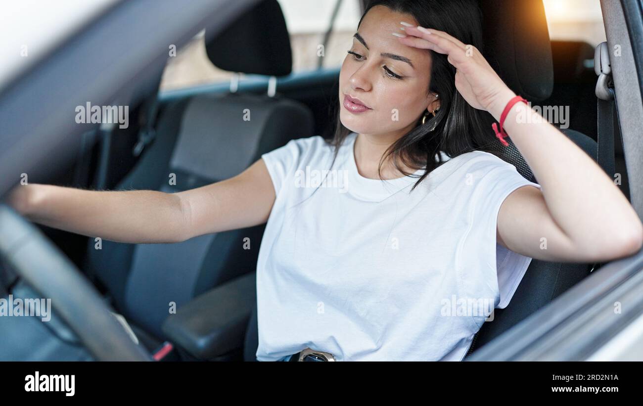 Young beautiful hispanic woman driving car at street Stock Photo - Alamy