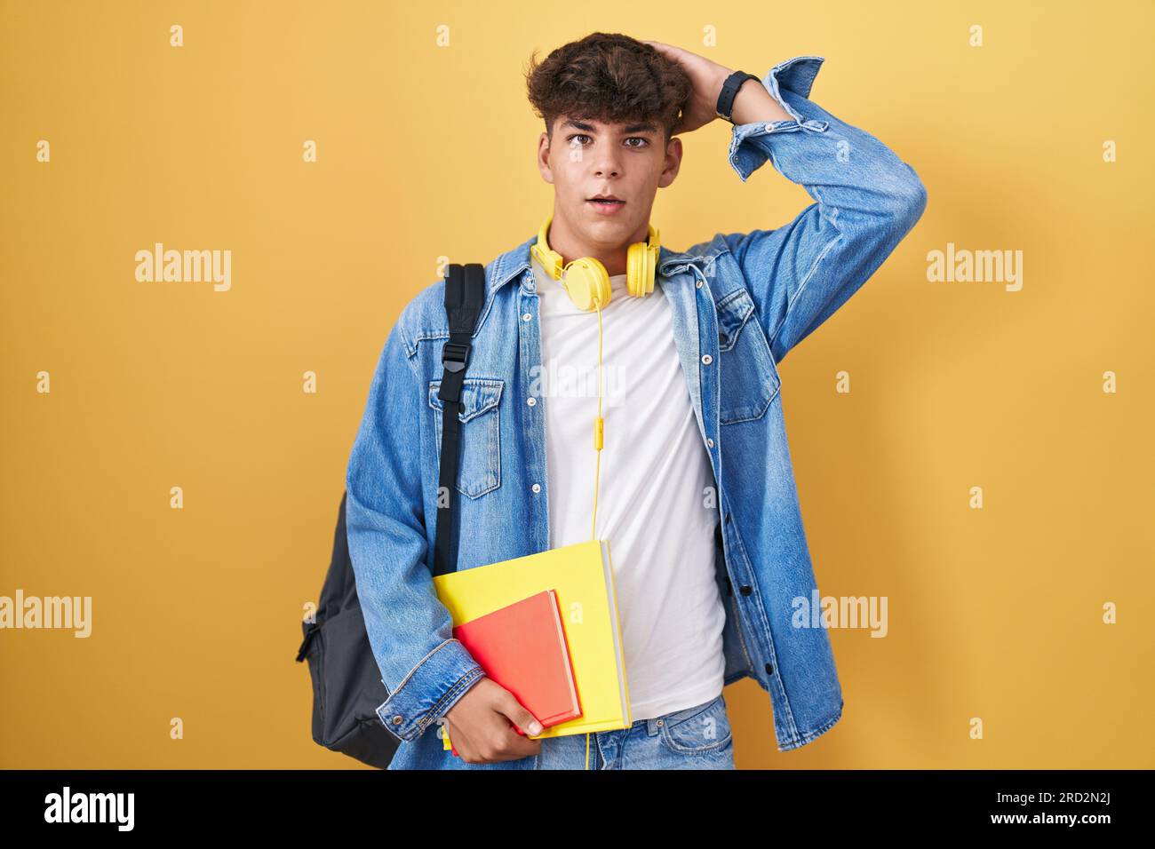 Hispanic teenager wearing student backpack and holding books crazy and ...