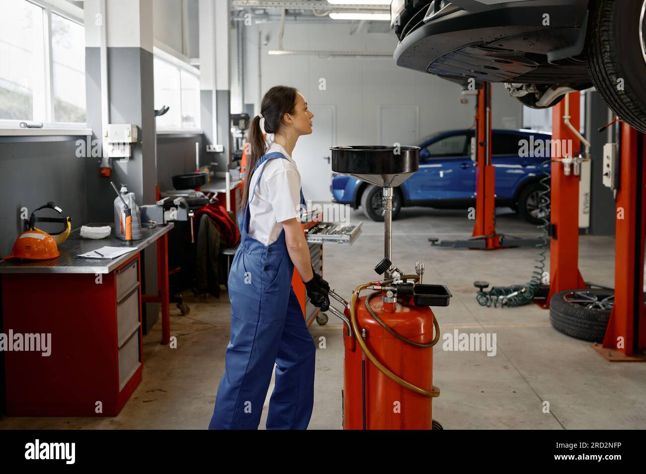 Woman mechanic pushing device for receiving used car engine oil Stock ...