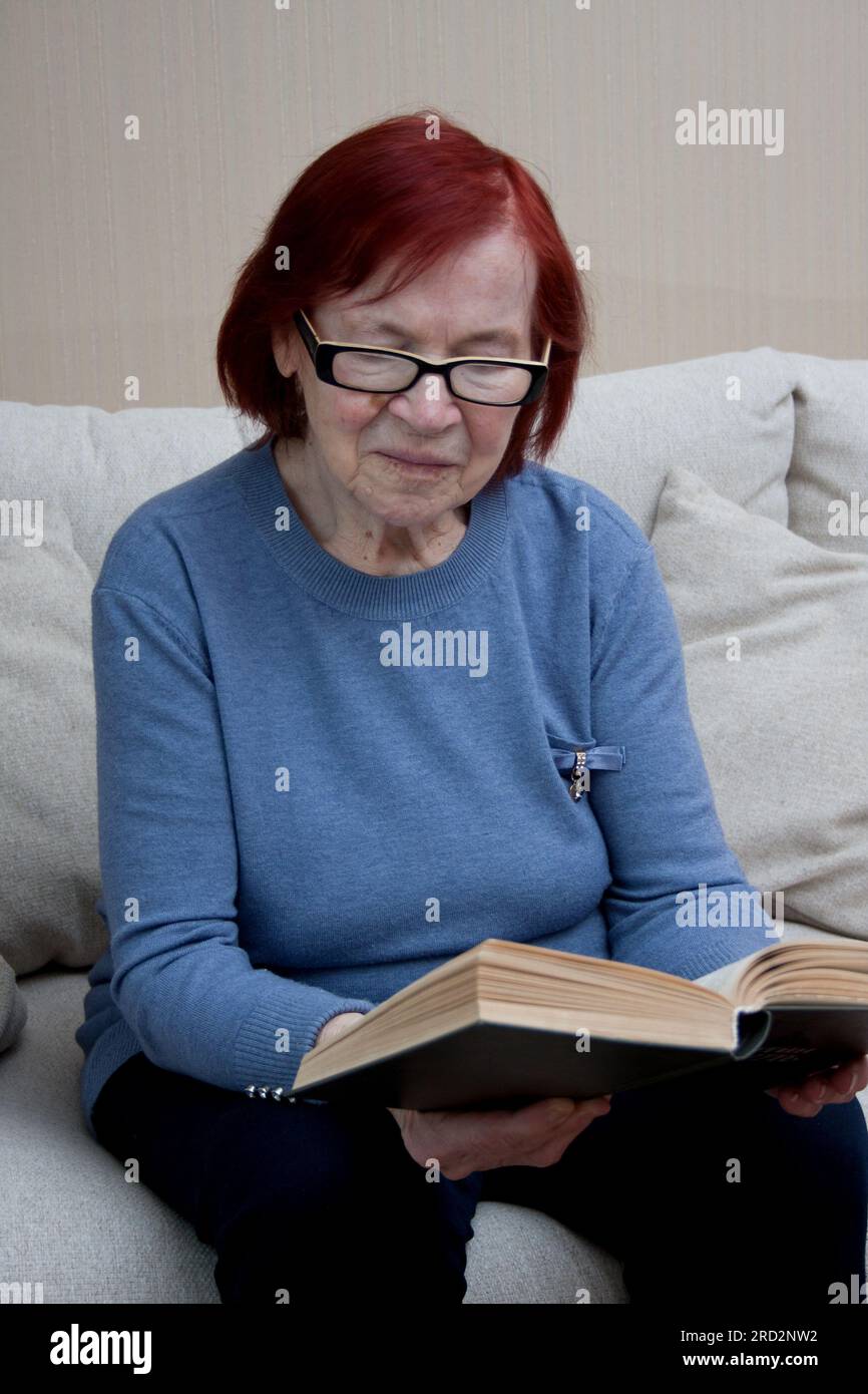 Portrait of elderly woman with book in hands. Senior woman spending ...
