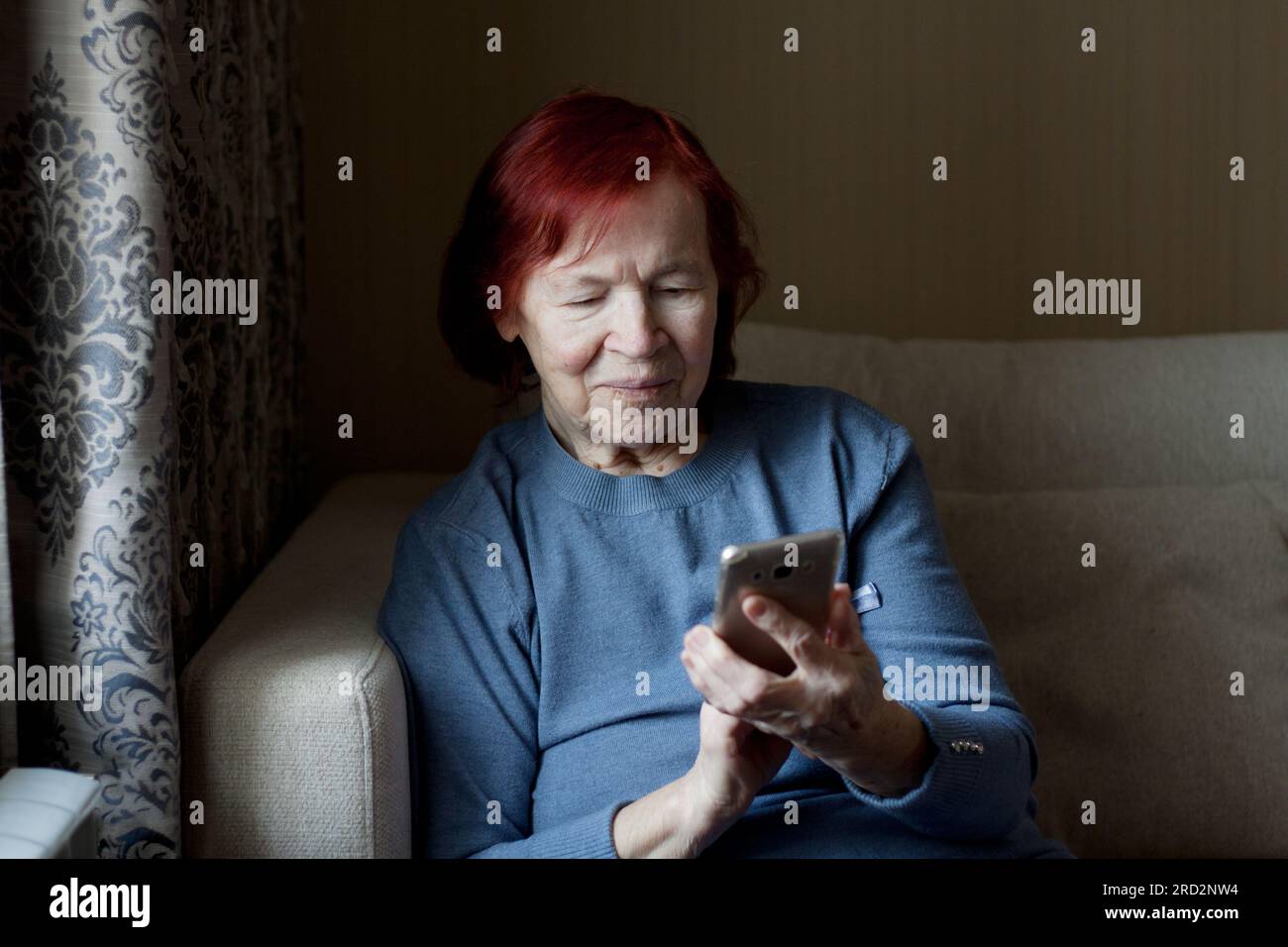 hands of an senior woman holding an old smartphone in her hands ...