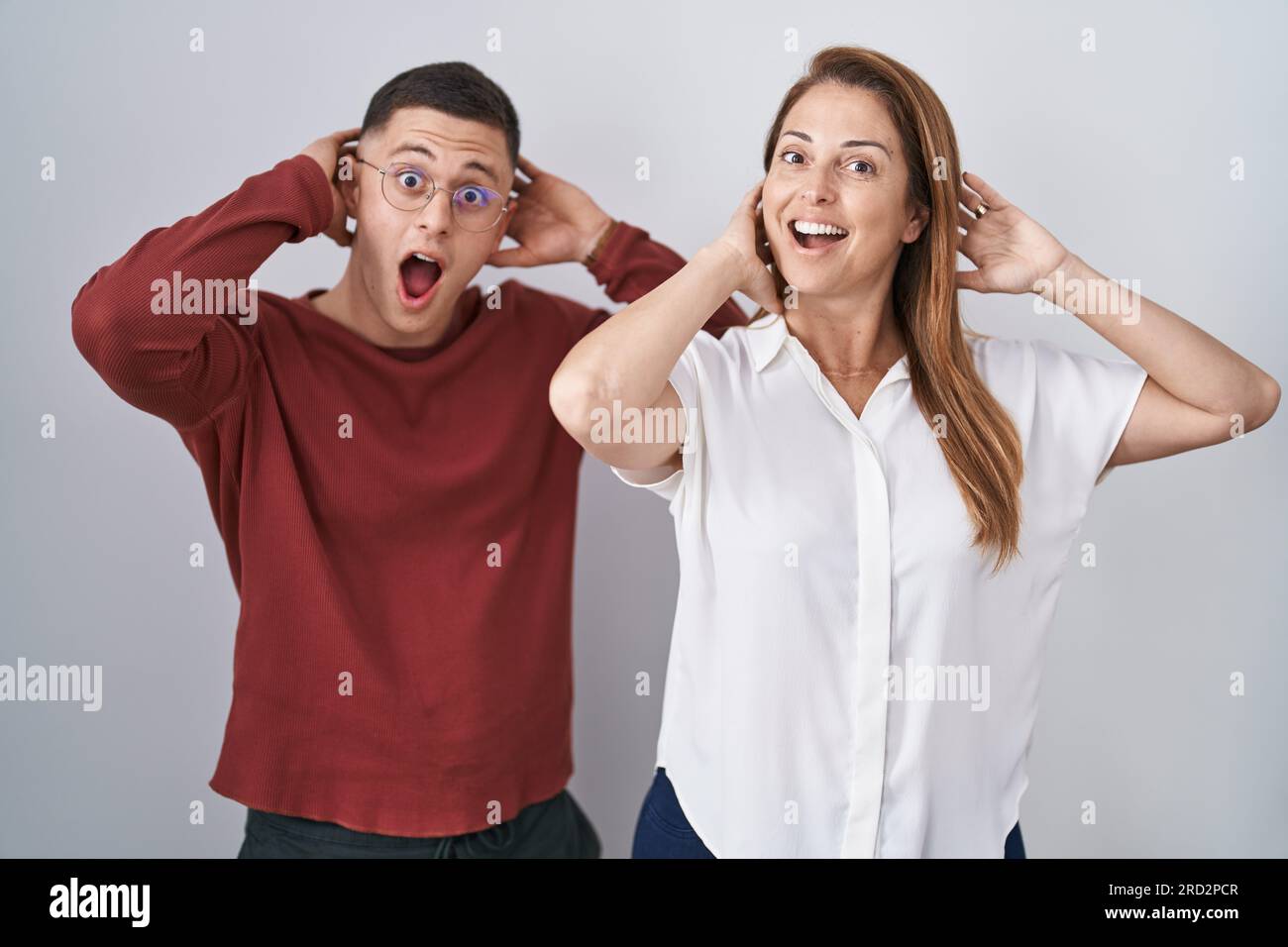 Mother and son standing together over isolated background crazy and ...