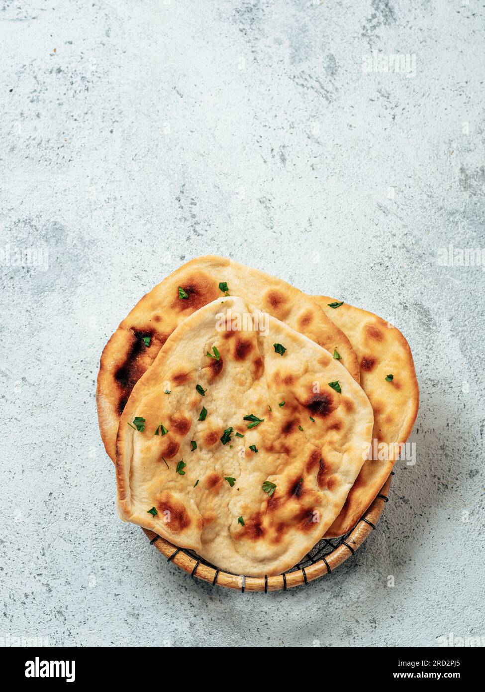 Fresh naan bread on gray cement background with copy space. Top view of ...