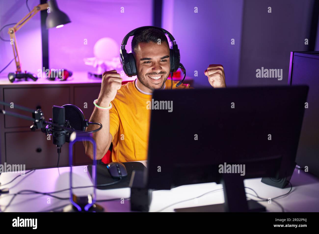 Young hispanic man streamer playing video game with winner expression ...
