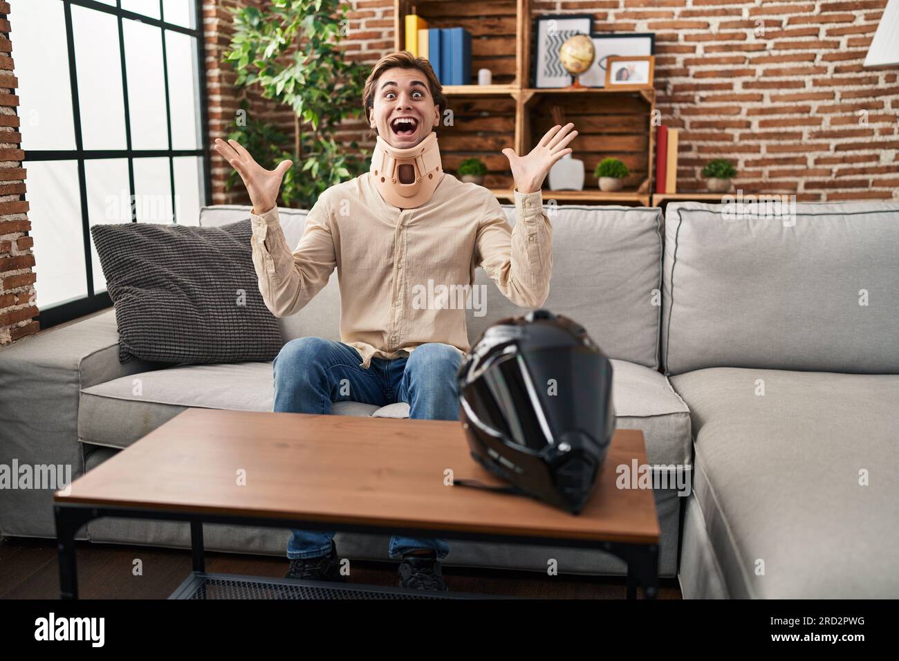 Young man wearing cervical collar for motorbike accident celebrating ...