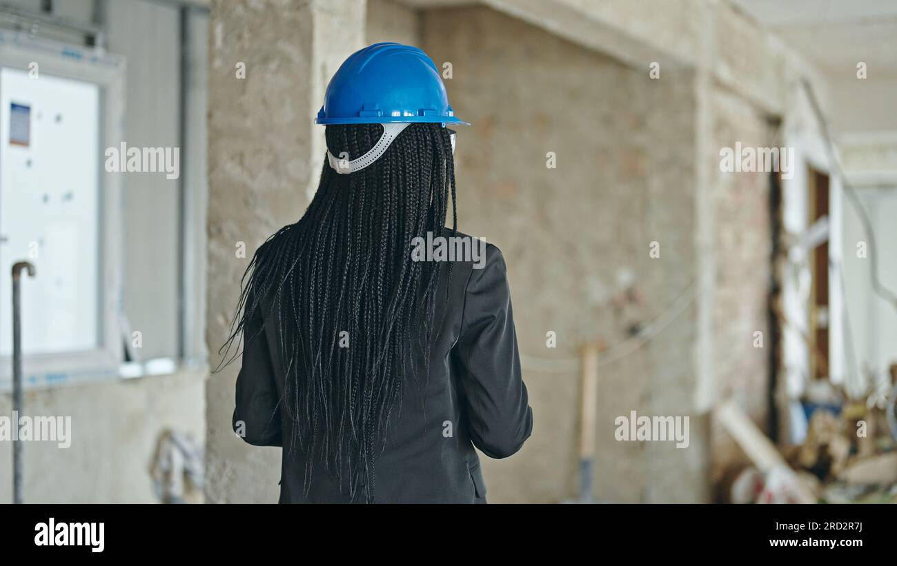 African american woman architect standing backwards at construction ...