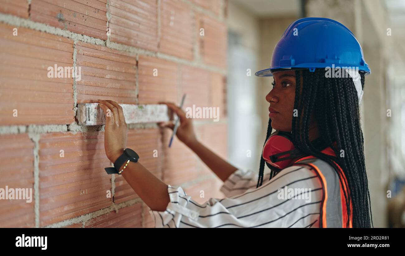 African american woman builder standing with relaxed expression ...