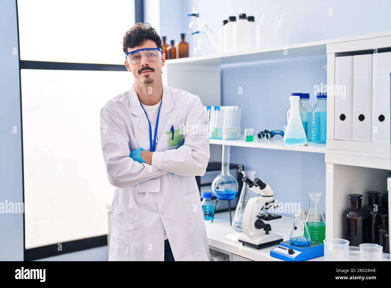 Young caucasian man scientist standing with relaxed expression and arms ...