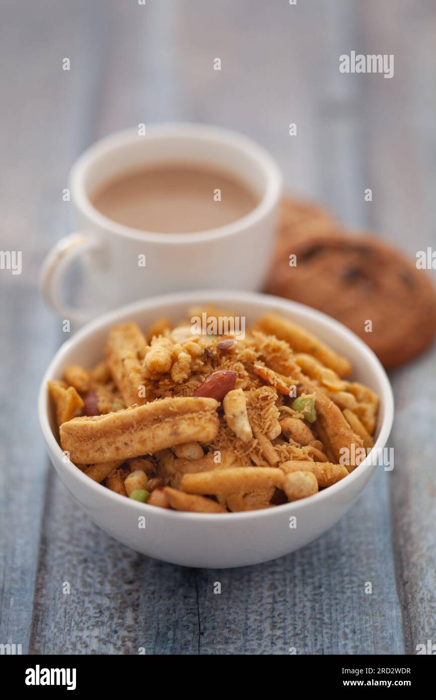 Close-Up of crunchy Indian mixture snacks with hot tea or Coffee time ...