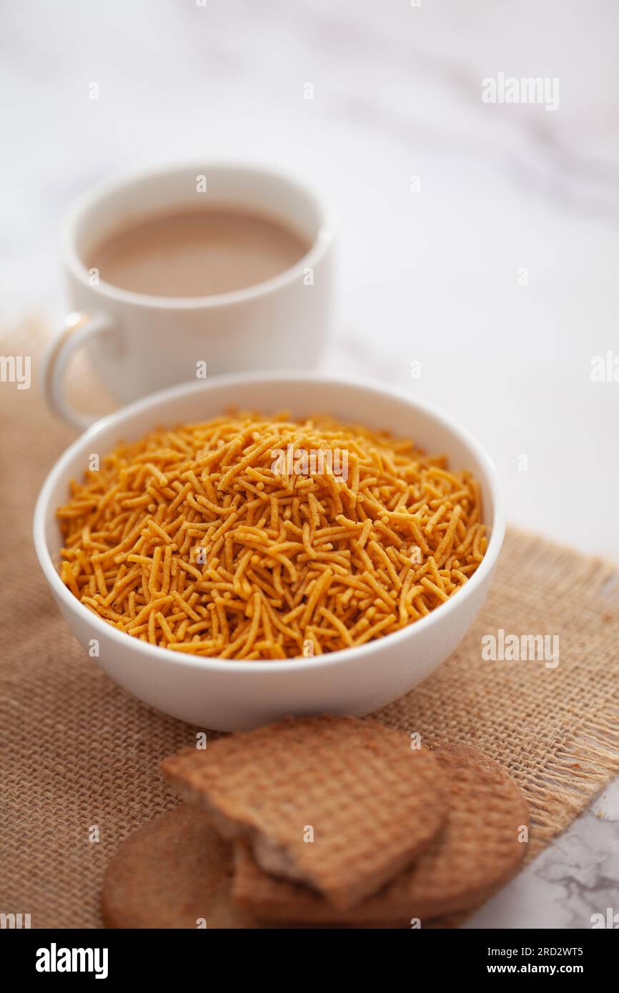 Close-Up of crunchy Indian mixture snacks with hot tea or Coffee time ...
