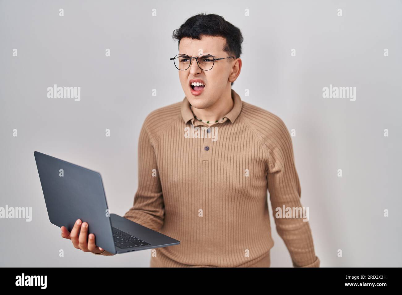 Non binary person using computer laptop angry and mad screaming ...
