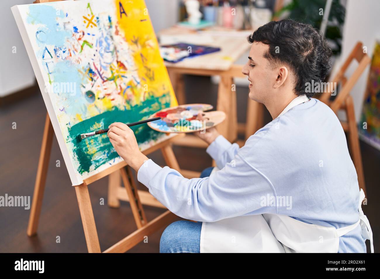 Young non binary man artist smiling confident drawing at art studio ...