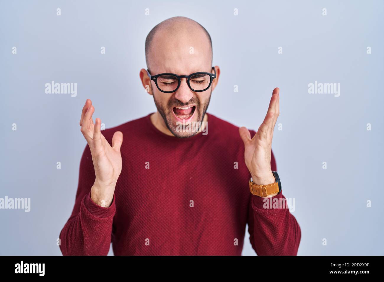 Young bald man with beard standing over white background wearing ...