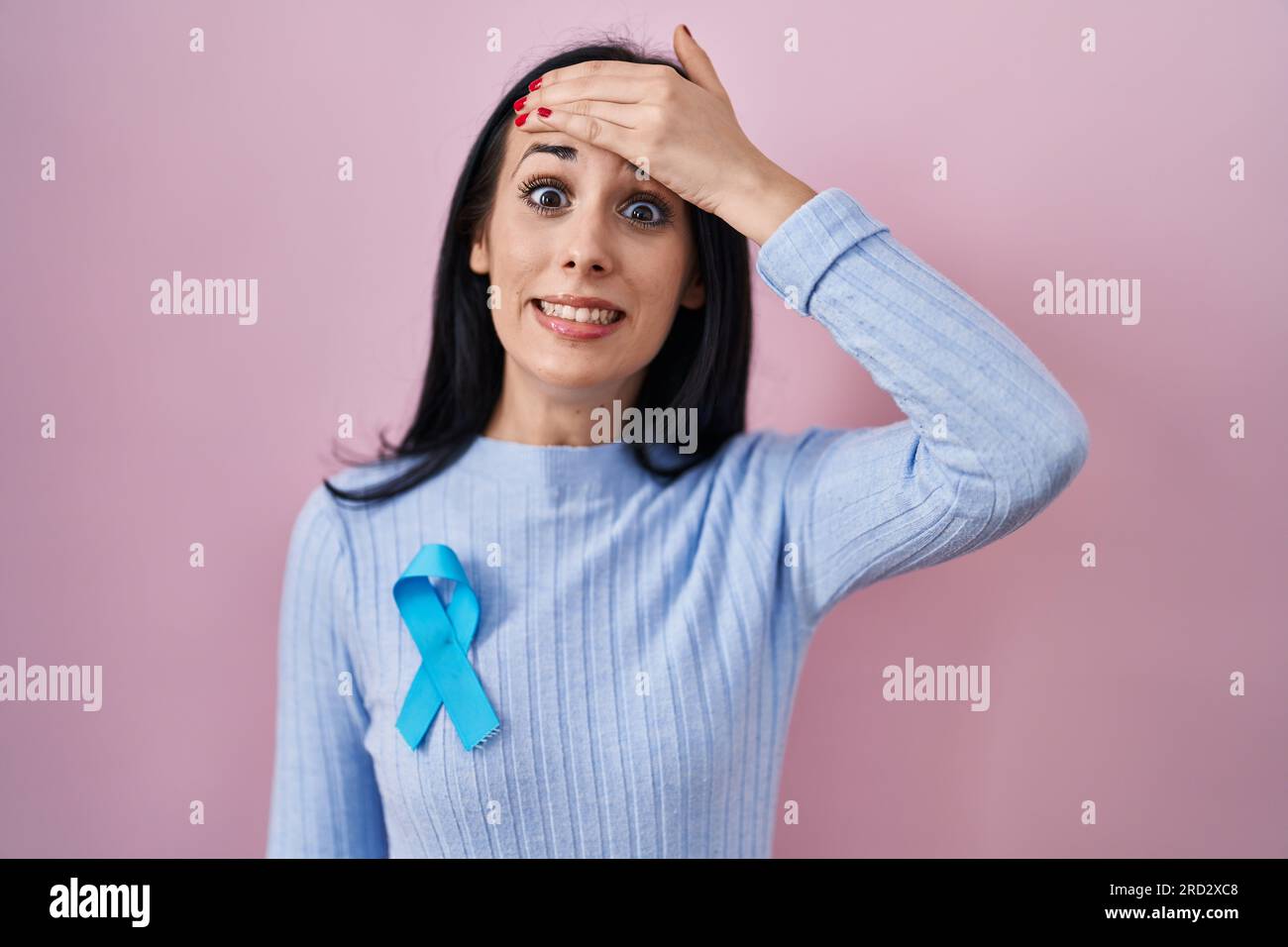 Hispanic woman wearing blue ribbon stressed and frustrated with hand on ...