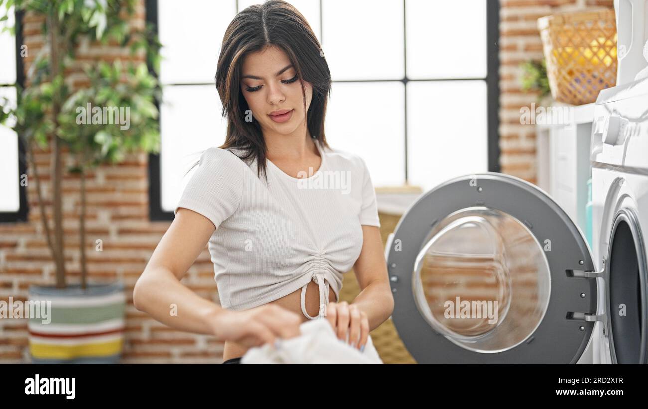 Young caucasian woman washing clothes at laundry room Stock Photo - Alamy