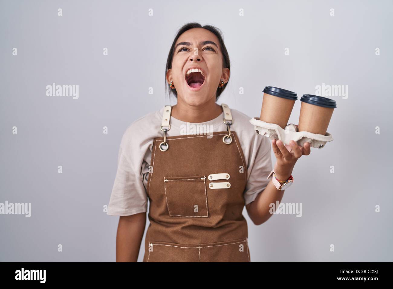 Young hispanic woman wearing professional waitress apron holding coffee ...