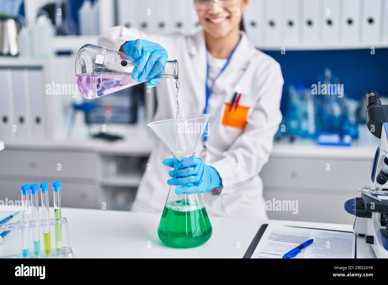 Young hispanic woman scientist measuring liquid at laboratory Stock ...
