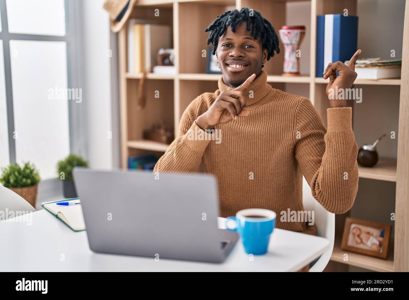 Young african man with dreadlocks working using computer laptop smiling ...