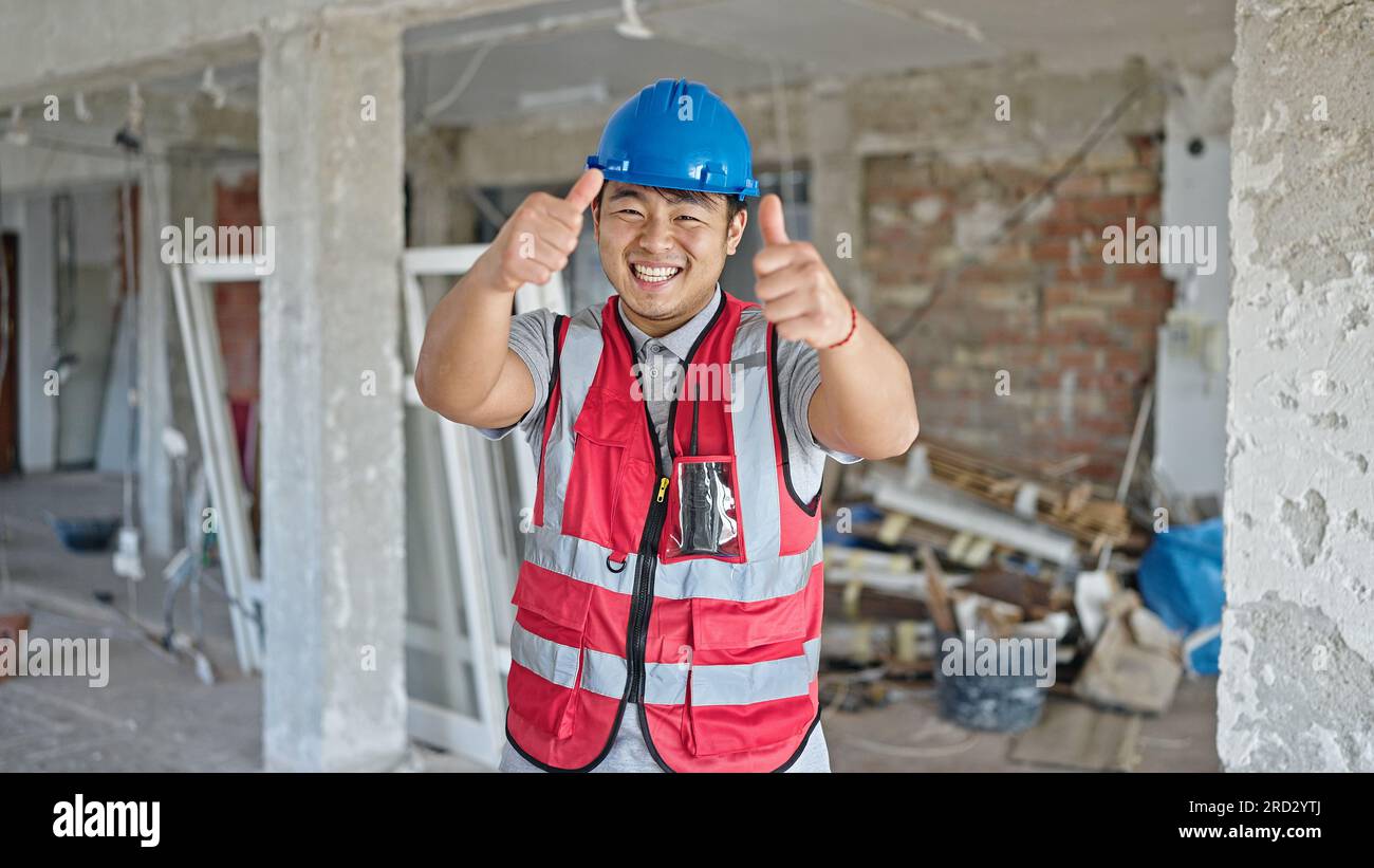 builder doing thumbs up gesture smiling at construction site Stock ...