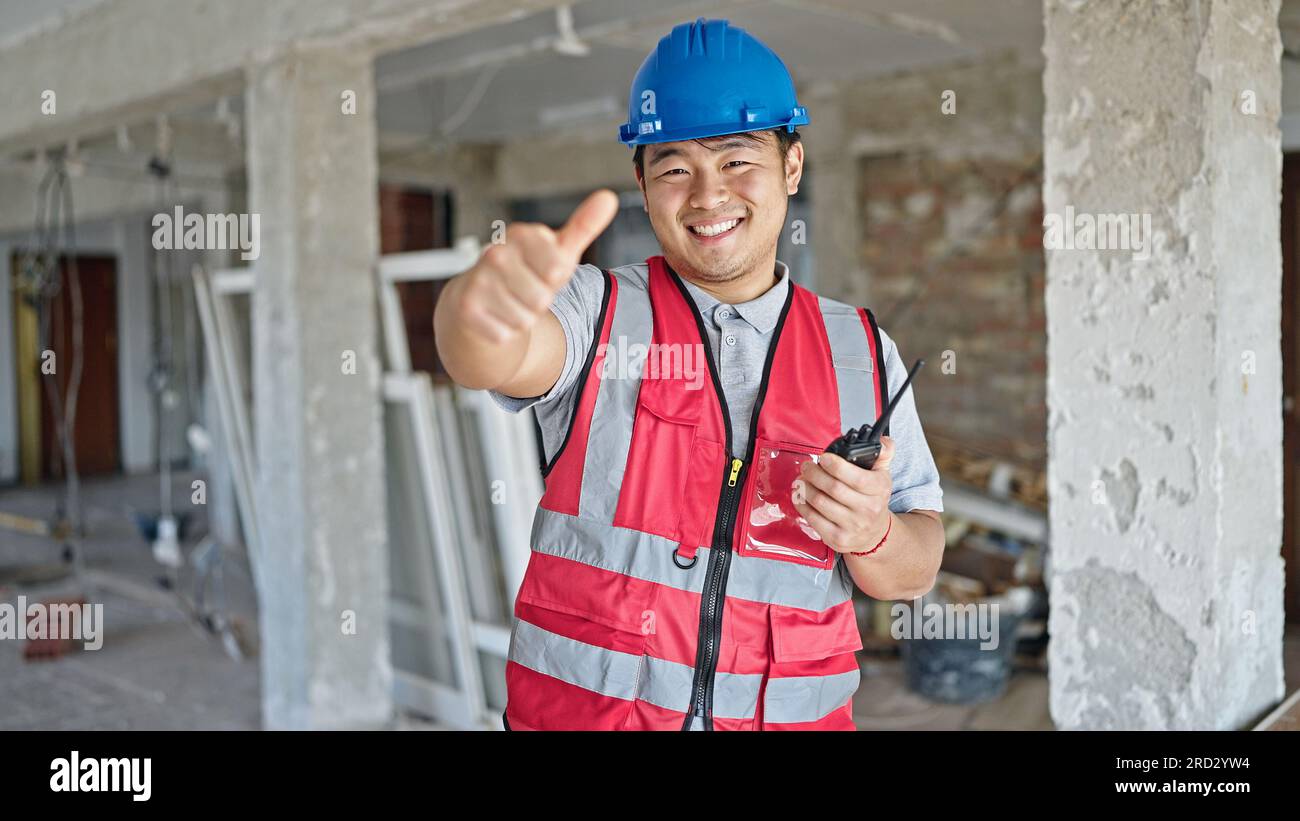 builder smiling confident doing thumb up gesture at construction site ...