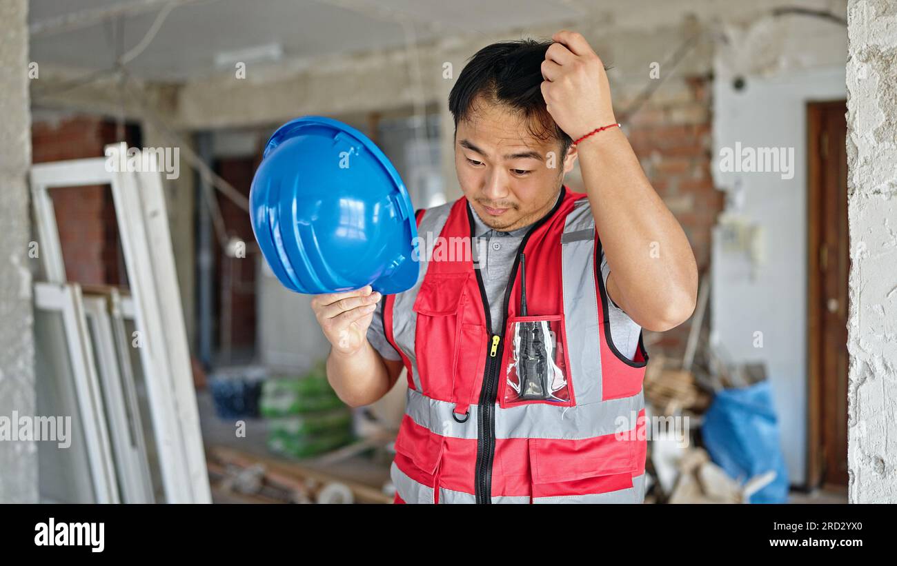 builder smiling confident combing hair at construction site Stock Photo ...