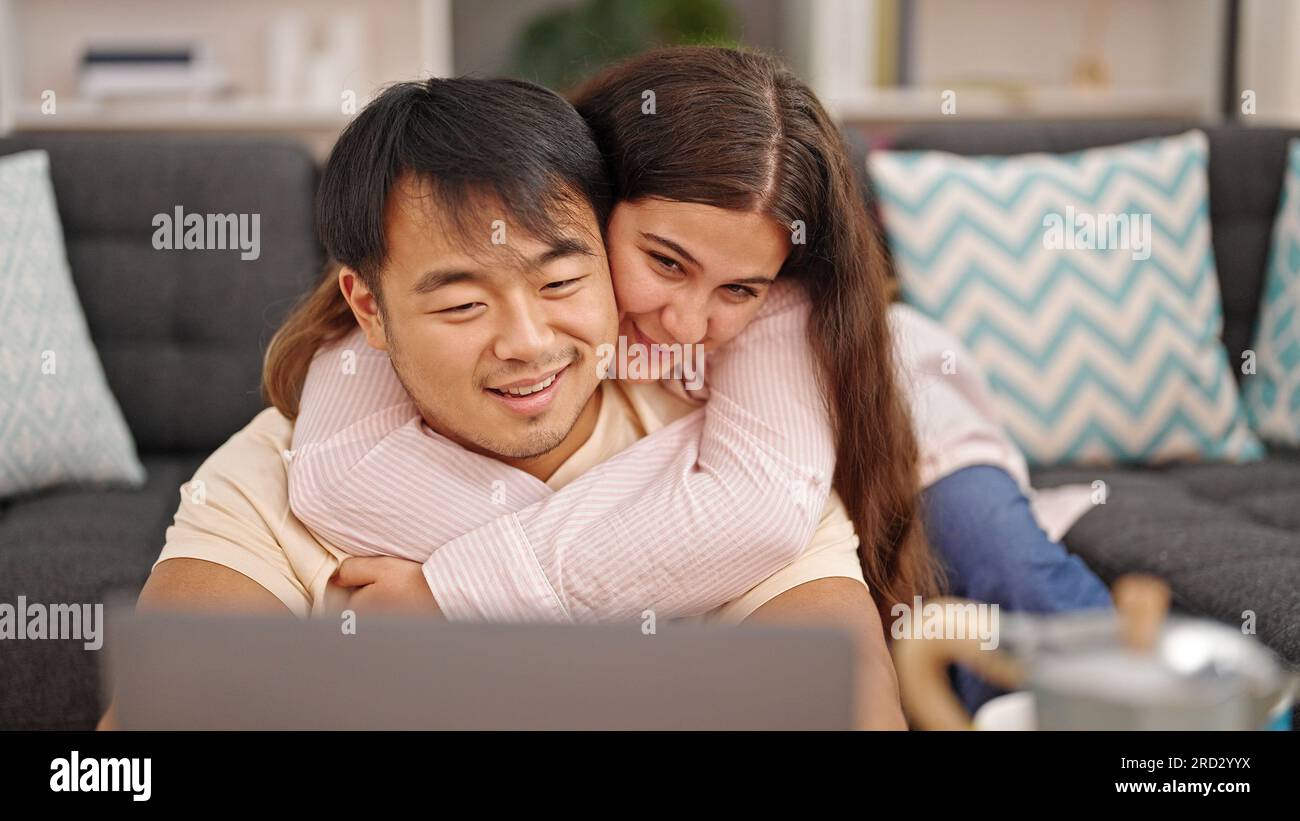 Man and woman couple using laptop hugging each other at home Stock ...